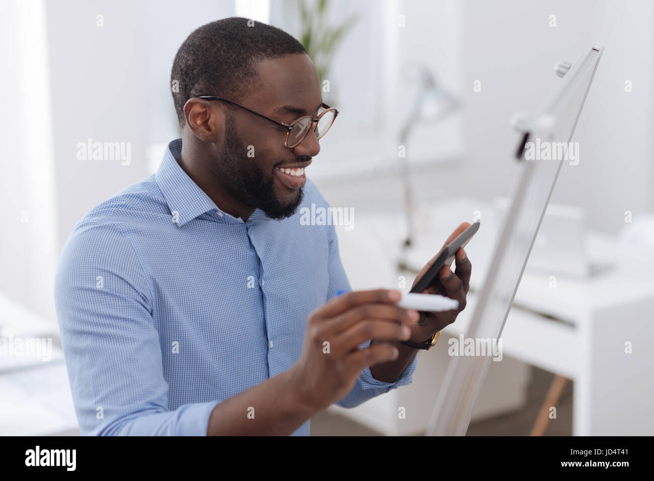 Smart cheerful man holding a highlighter Stock Photo - Alamy