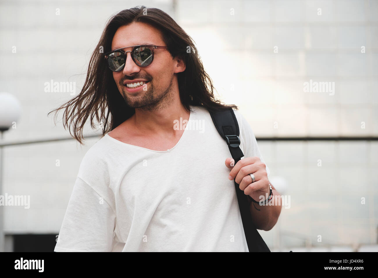 Stylish hipster model with long hair lifestyle in the street. Dressed ...