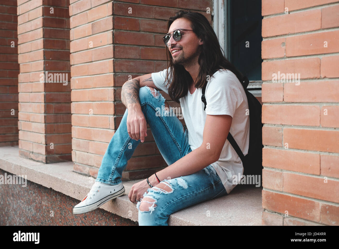 Stylish hipster model with long hair lifestyle in the street. Dressed ...