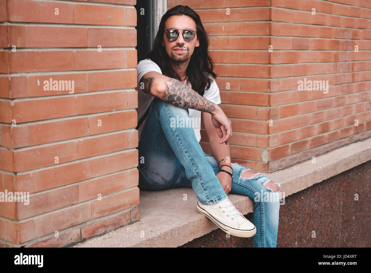 Stylish hipster model with long hair lifestyle in the street. Dressed ...