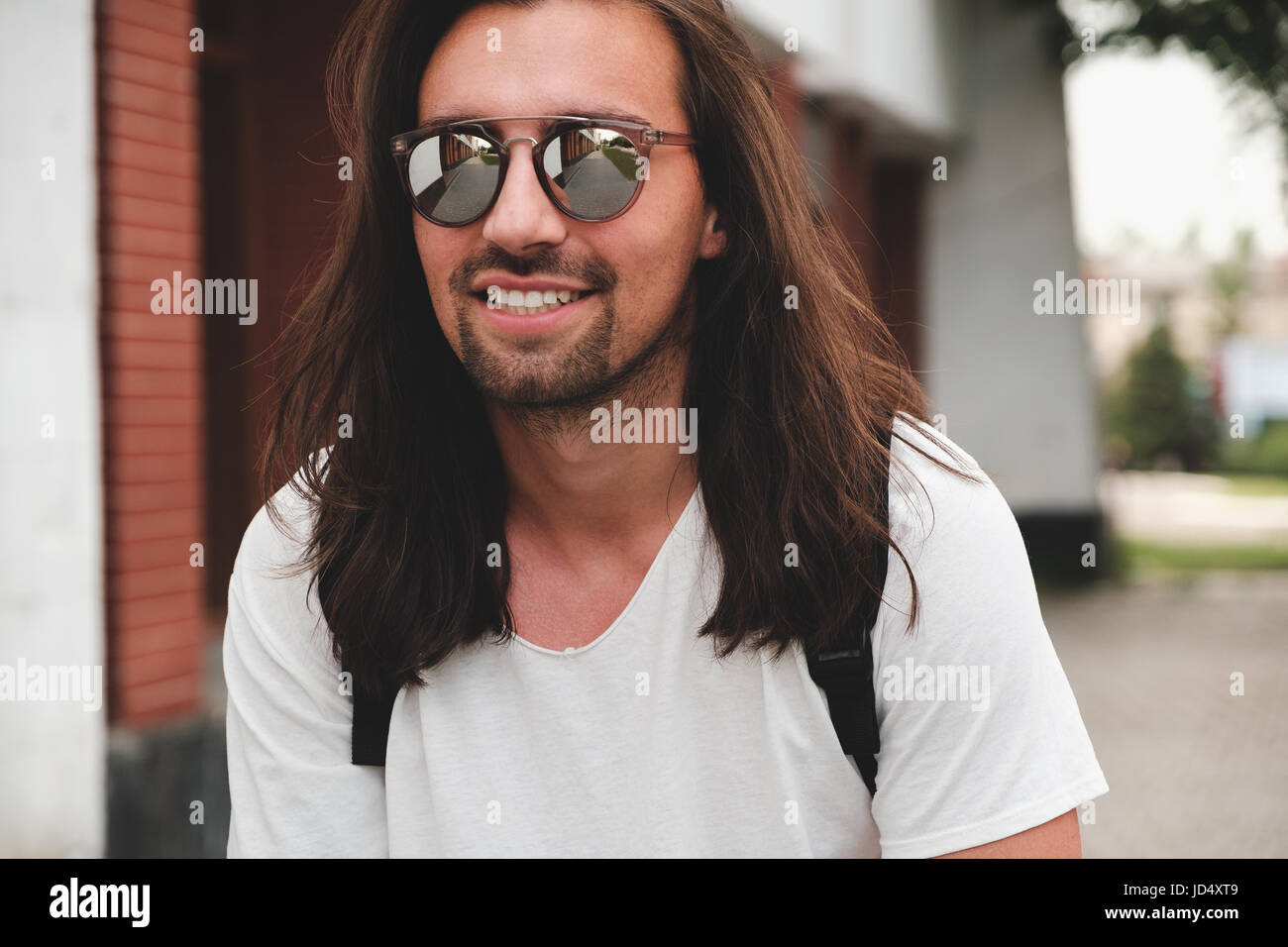 Stylish hipster model with long hair lifestyle in the street. Dressed ...