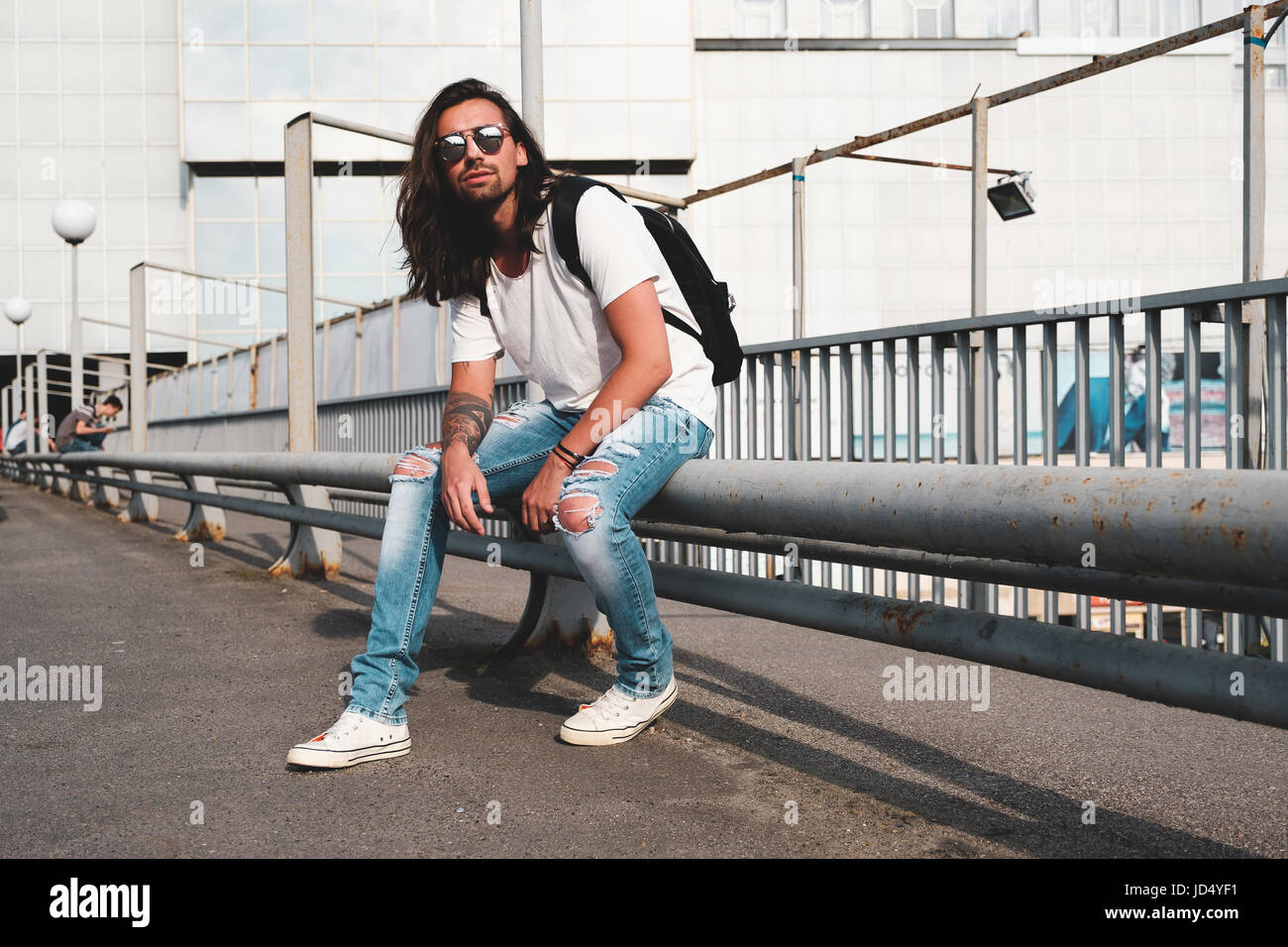 Stylish hipster model with long hair lifestyle in the street. Dressed ...