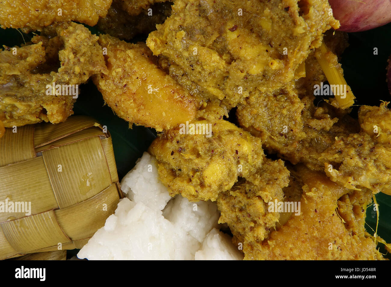 Malaysian dish Rendang Ayam or dry curry chicken and Ketupat Nasi (Rice ...