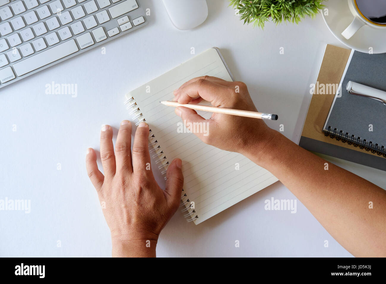 Man writing notebook or working on white desk workspace office table ...