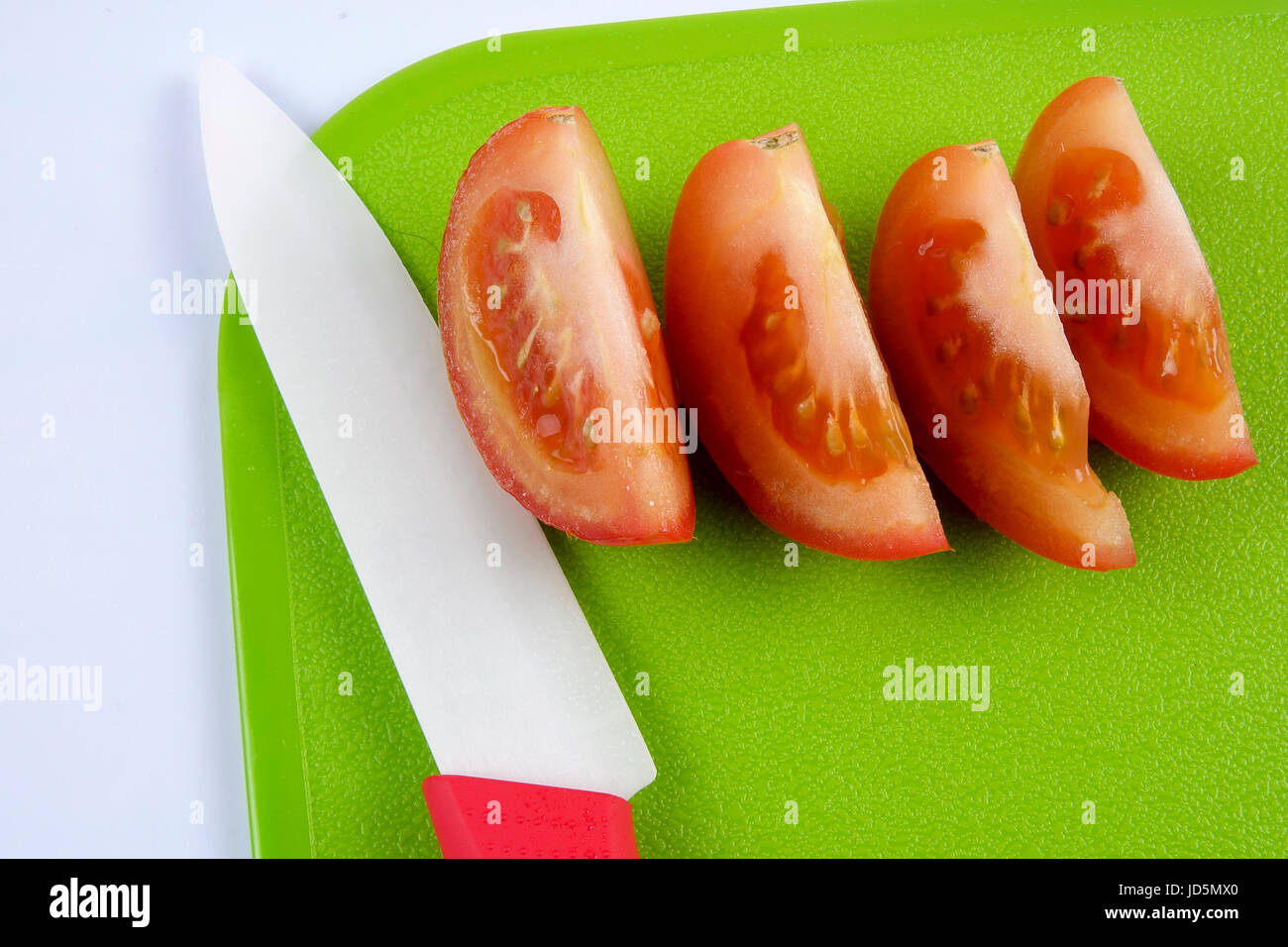 Sliced tomato on green chopping board Stock Photo - Alamy