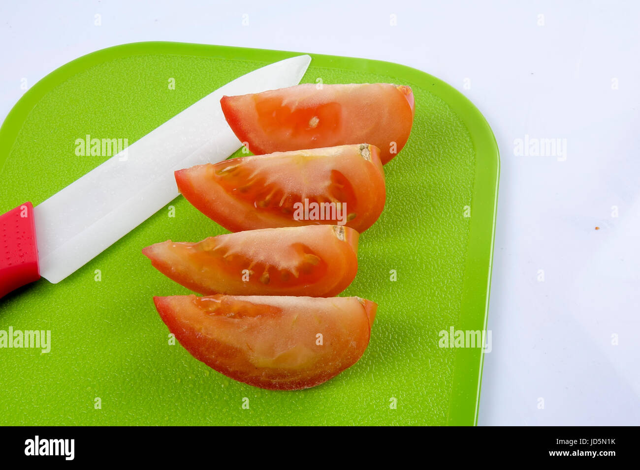 Sliced tomato on green chopping board Stock Photo - Alamy