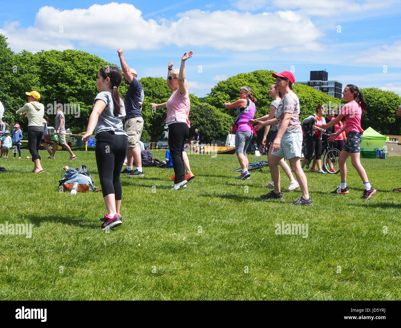 People taking part in a mixed age and ability exercise class outdoors ...