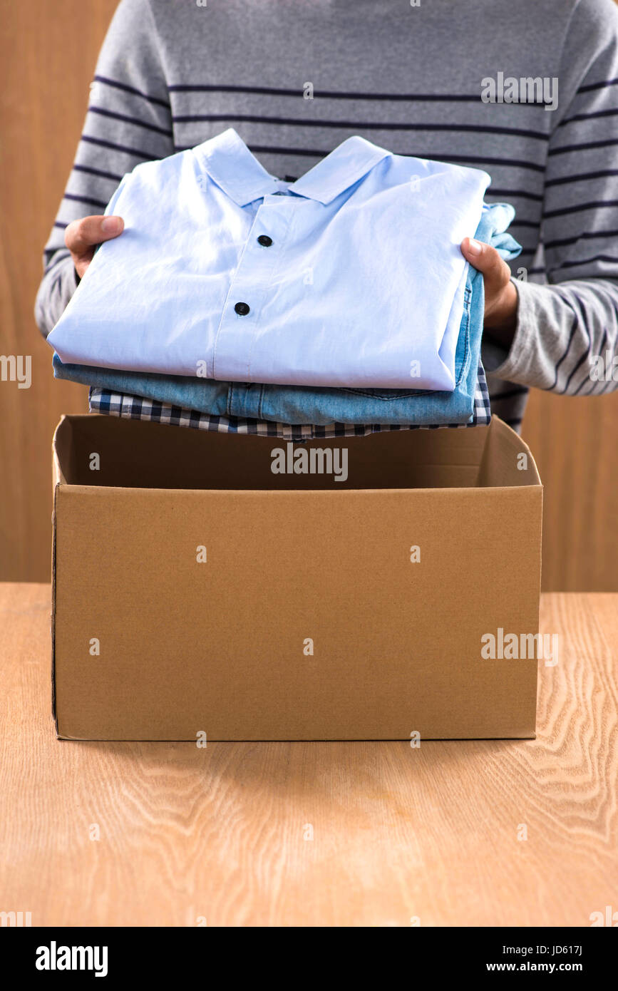 Donation box for poor with clothing in male hands Stock Photo - Alamy