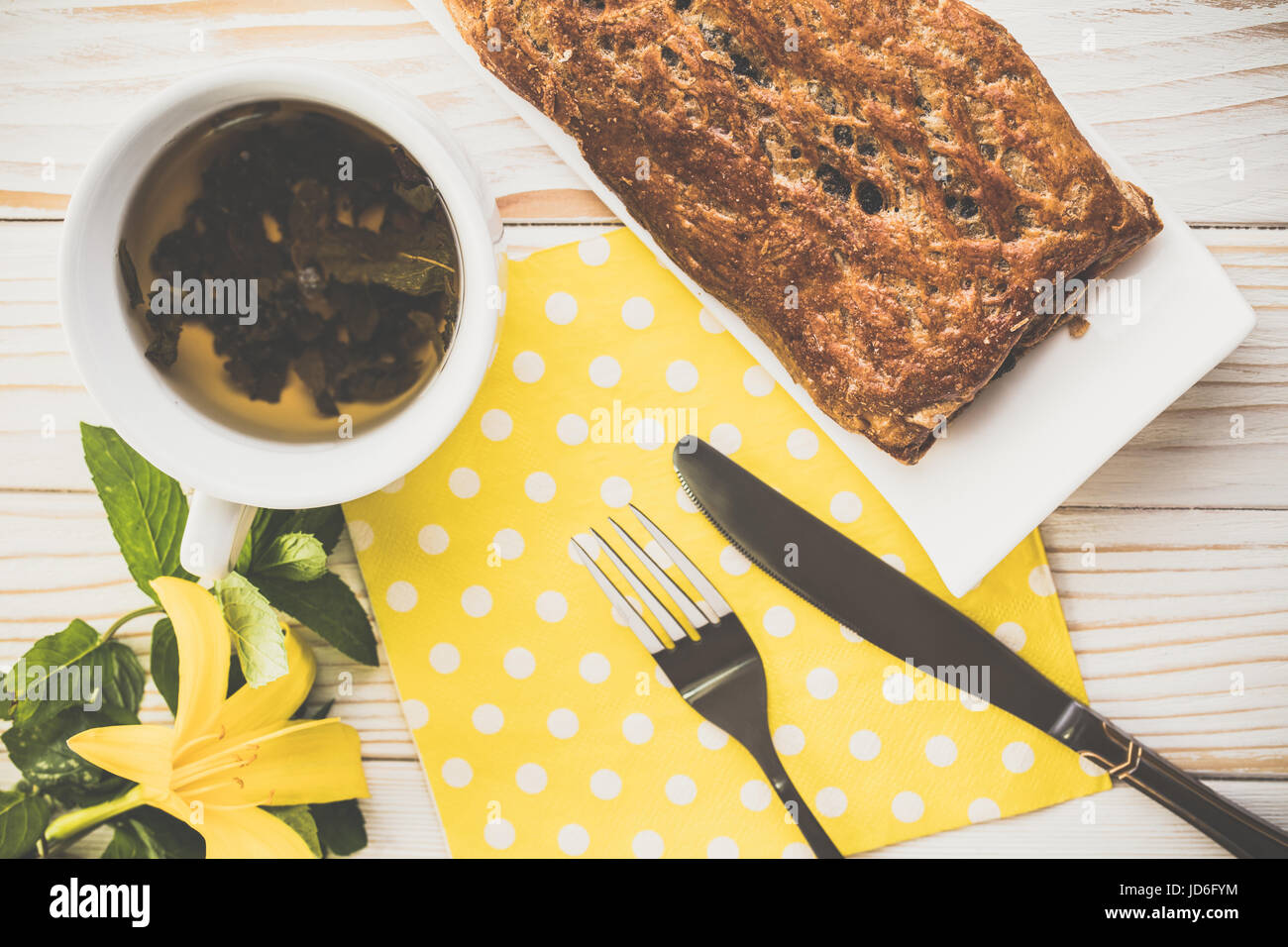Baking strudel with poppy seeds and tea on a wooden white background ...