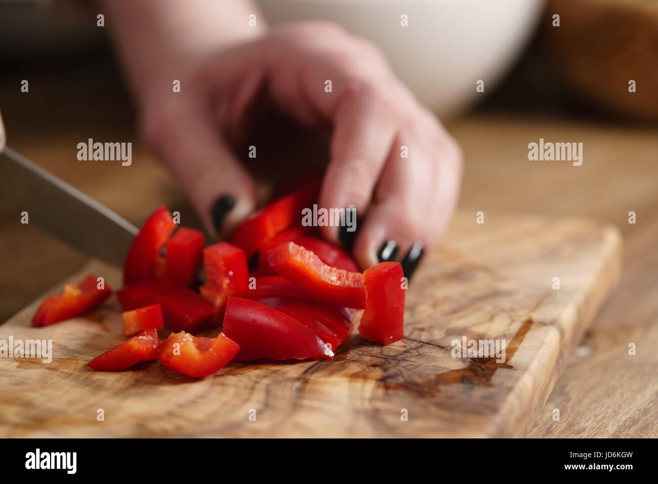 young female hands chopping red bell pepper on kitchen table Stock ...