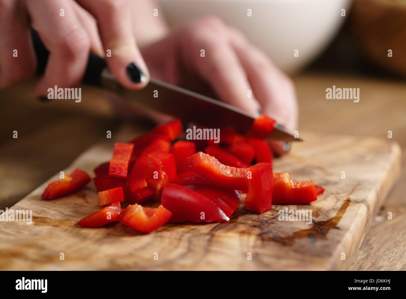 young female hands chopping red bell pepper on kitchen table Stock ...