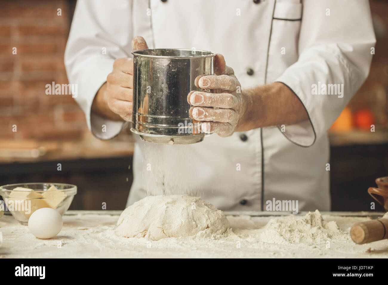 Bakery chef cooking bake in the kitchen professional sift the flour ...