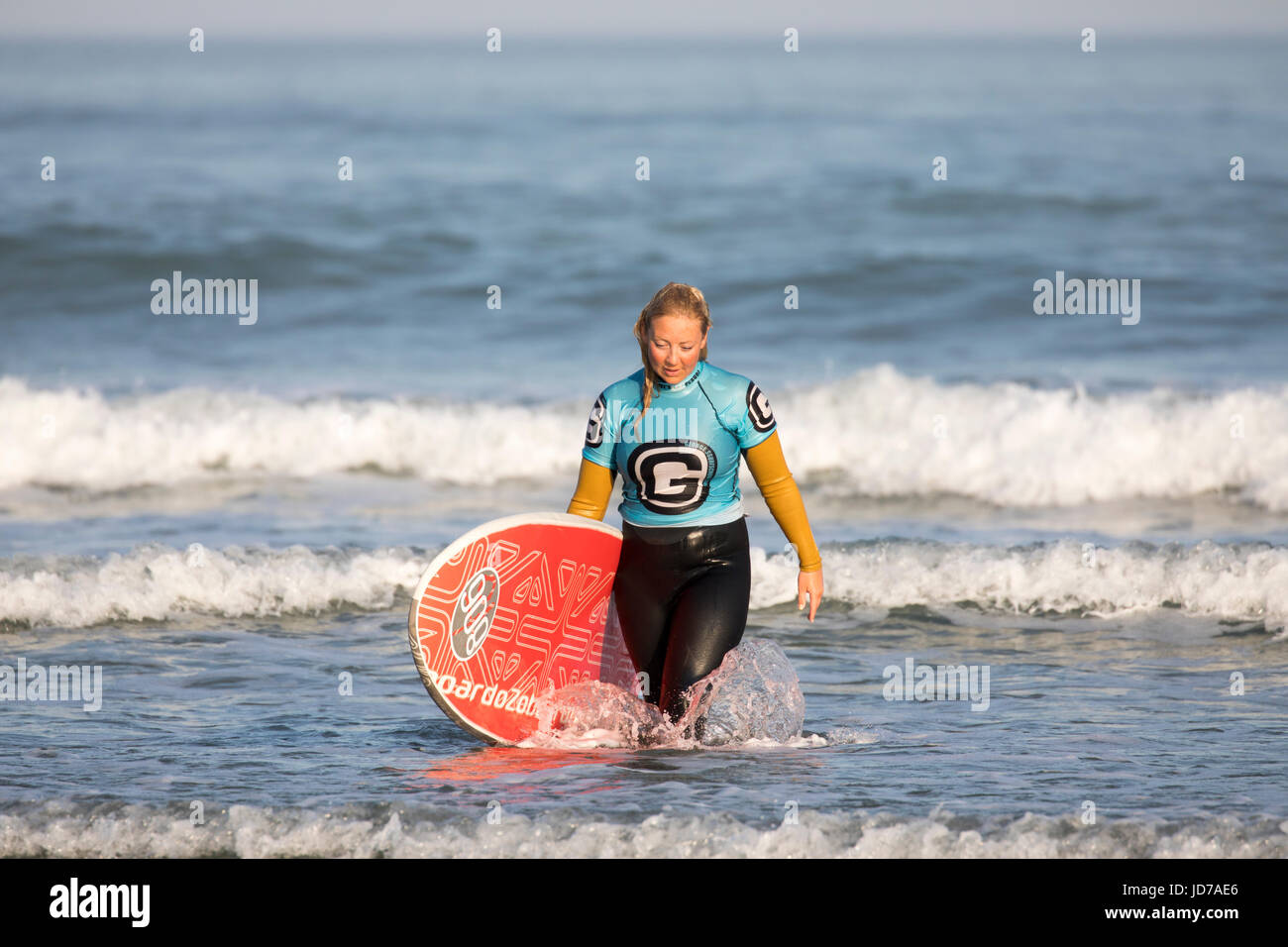 Female surfer holding surf board during hot summer weather at the ...