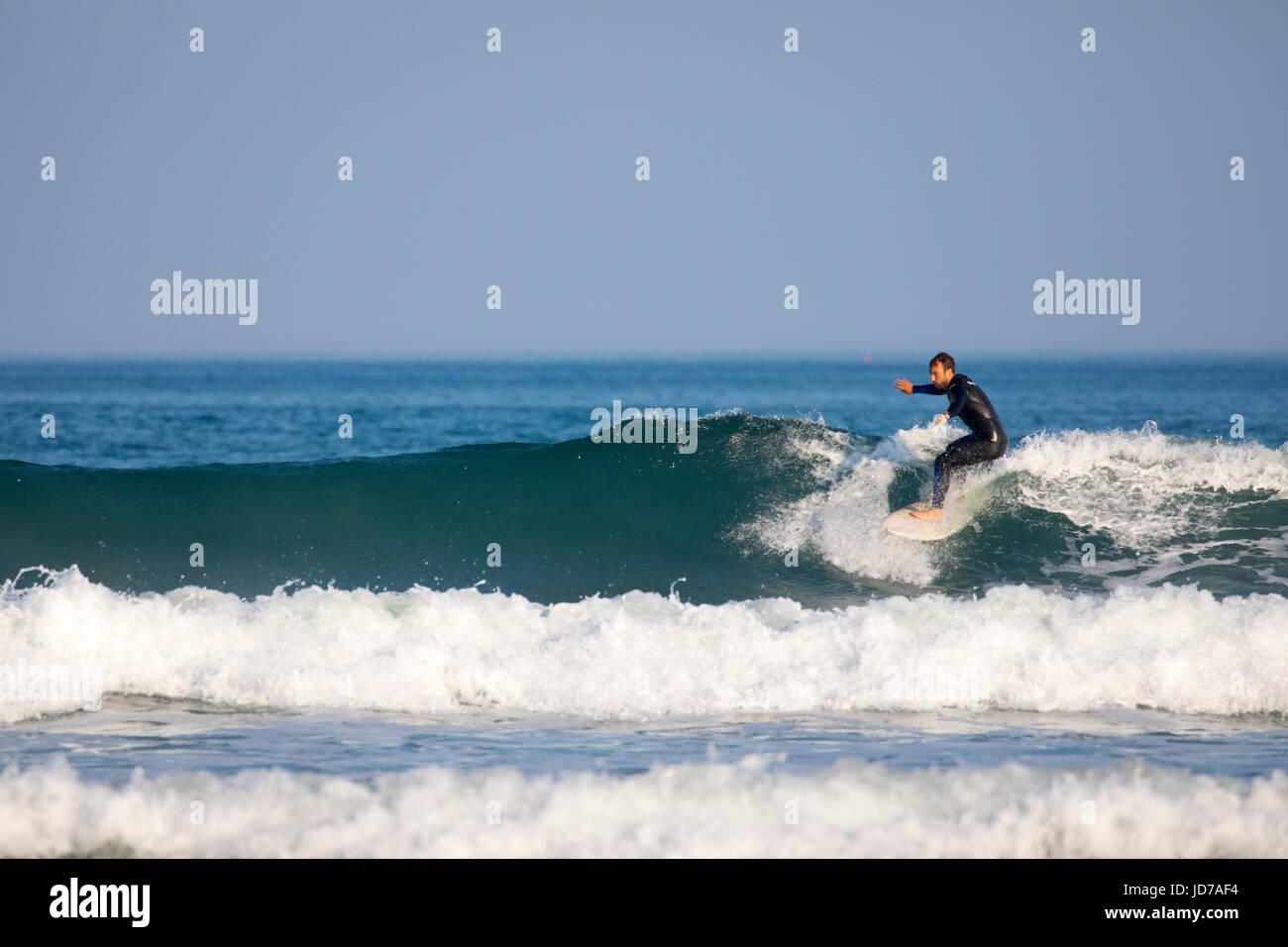A surfer riding a wave during a summers morning at the renowned UK ...