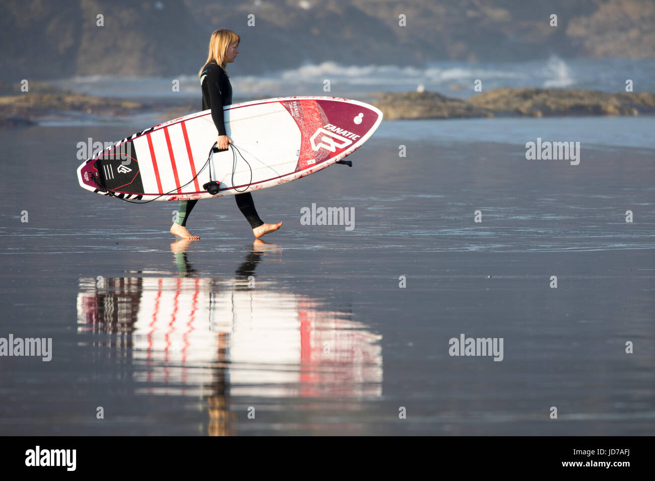 Female surfer holding surf board during hot summer weather at the ...