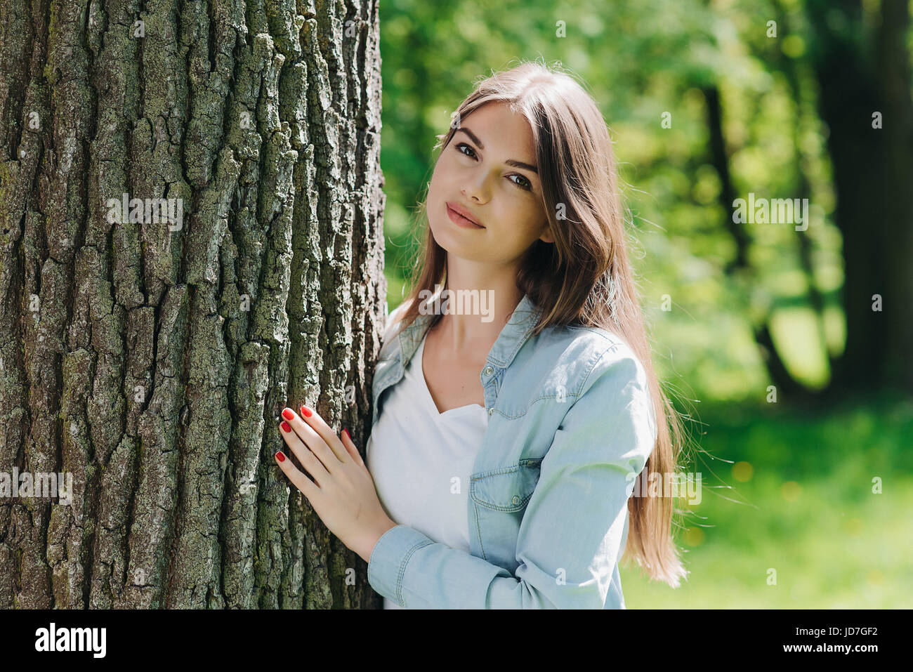 Young woman hugging a big tree, love nature concept Stock Photo - Alamy