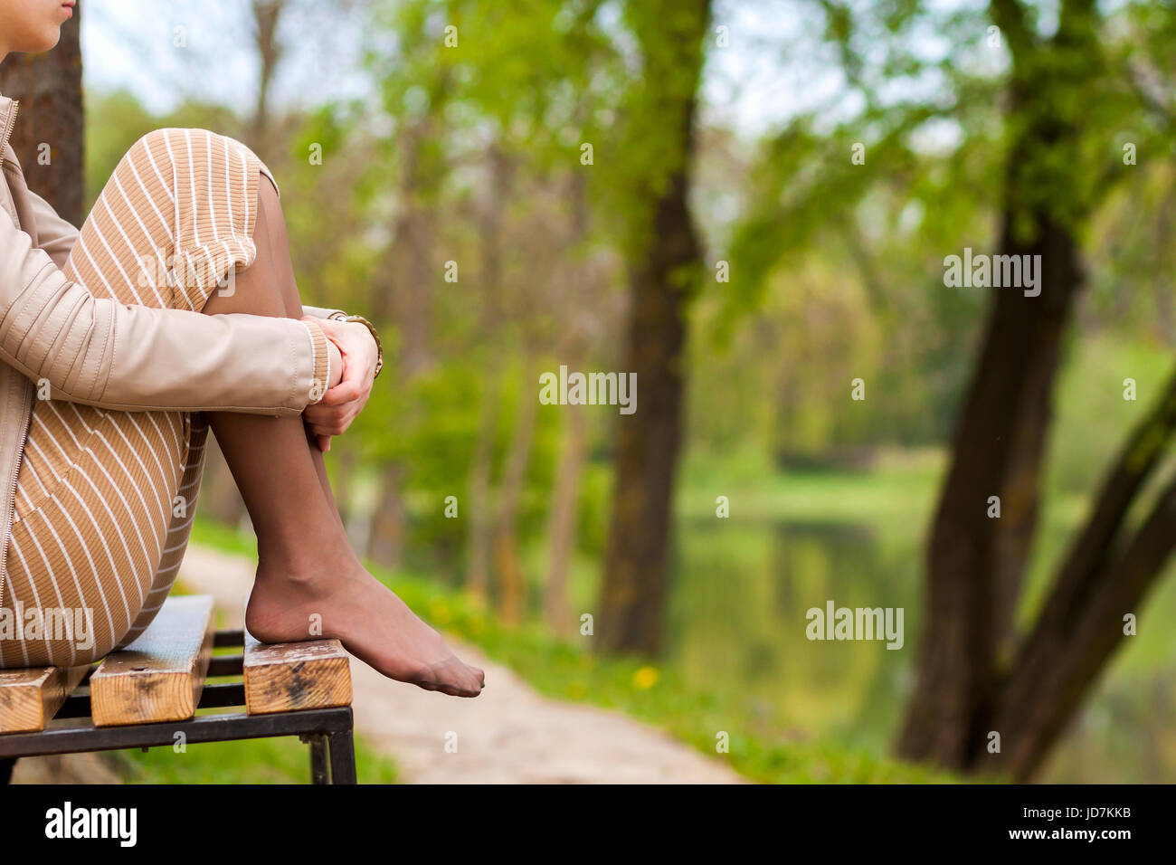 Feet of beautiful young woman sitting on bench in park Stock Photo - Alamy