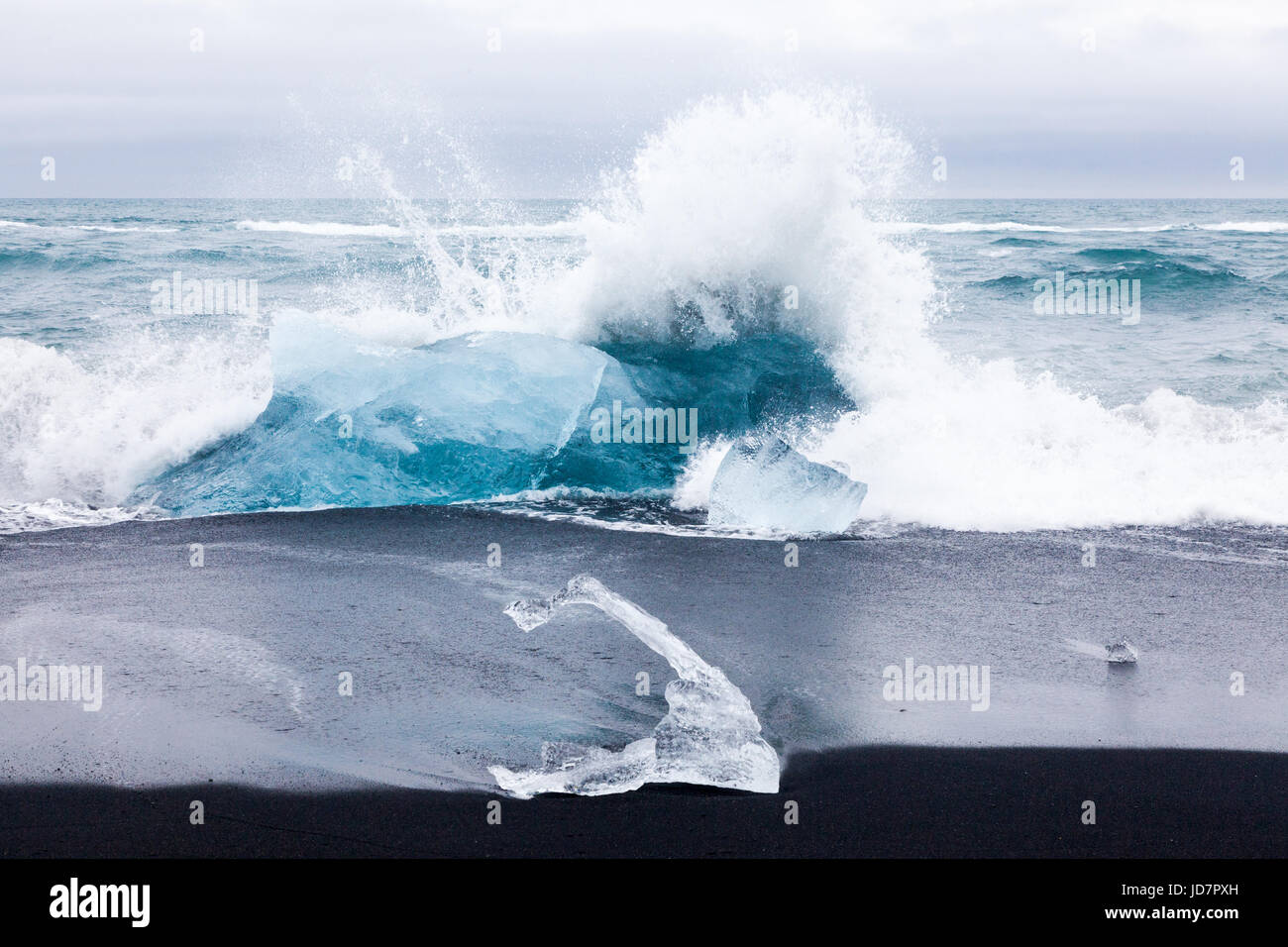 Large chunks of glacial ice being washed up on a beach by the ...