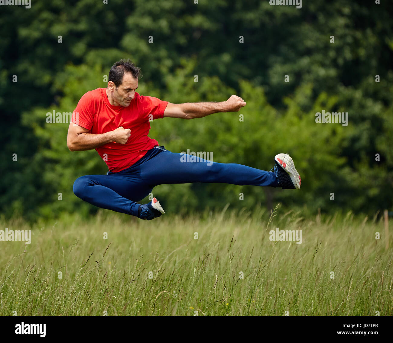 Kickbox fighter executing a lateral jumping kick outdoor Stock Photo ...