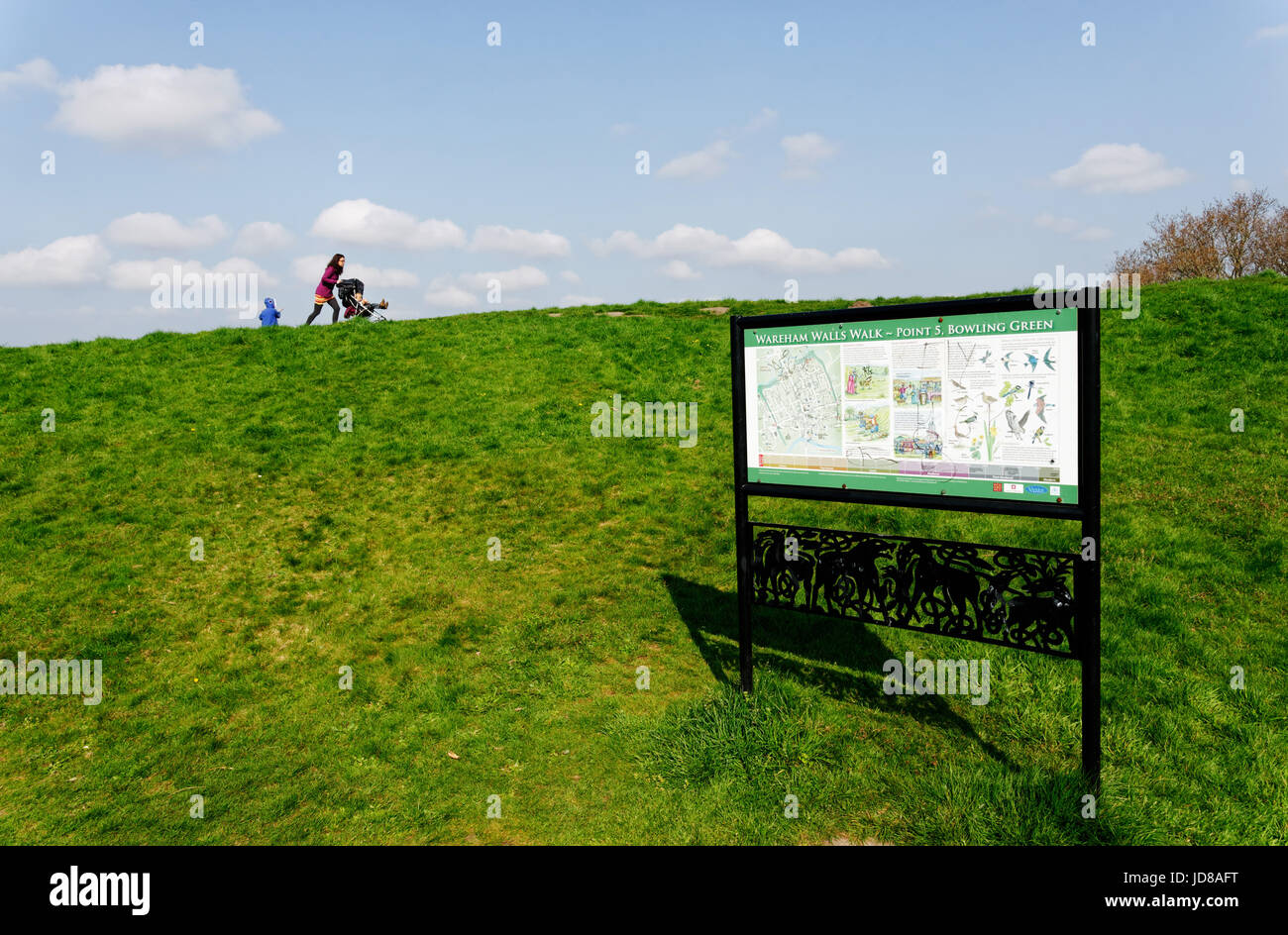 A child and a woman pushing a pushchair along the Wareham Walls Walk in ...