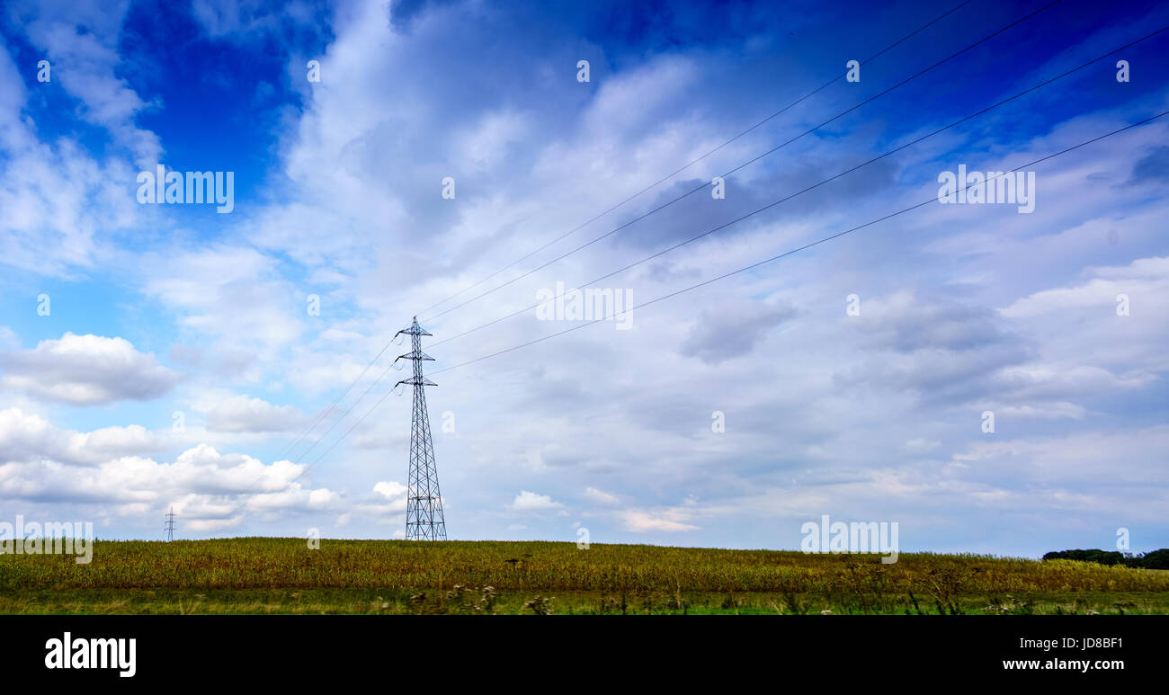 Panoramic shot of electricity pylon in field against sky with clouds ...