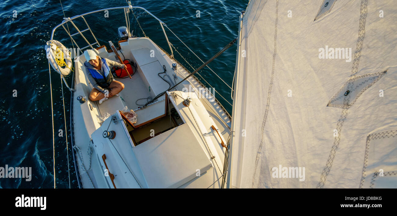 Overhead view of woman sat in sailboat on water, summer. sailing ...