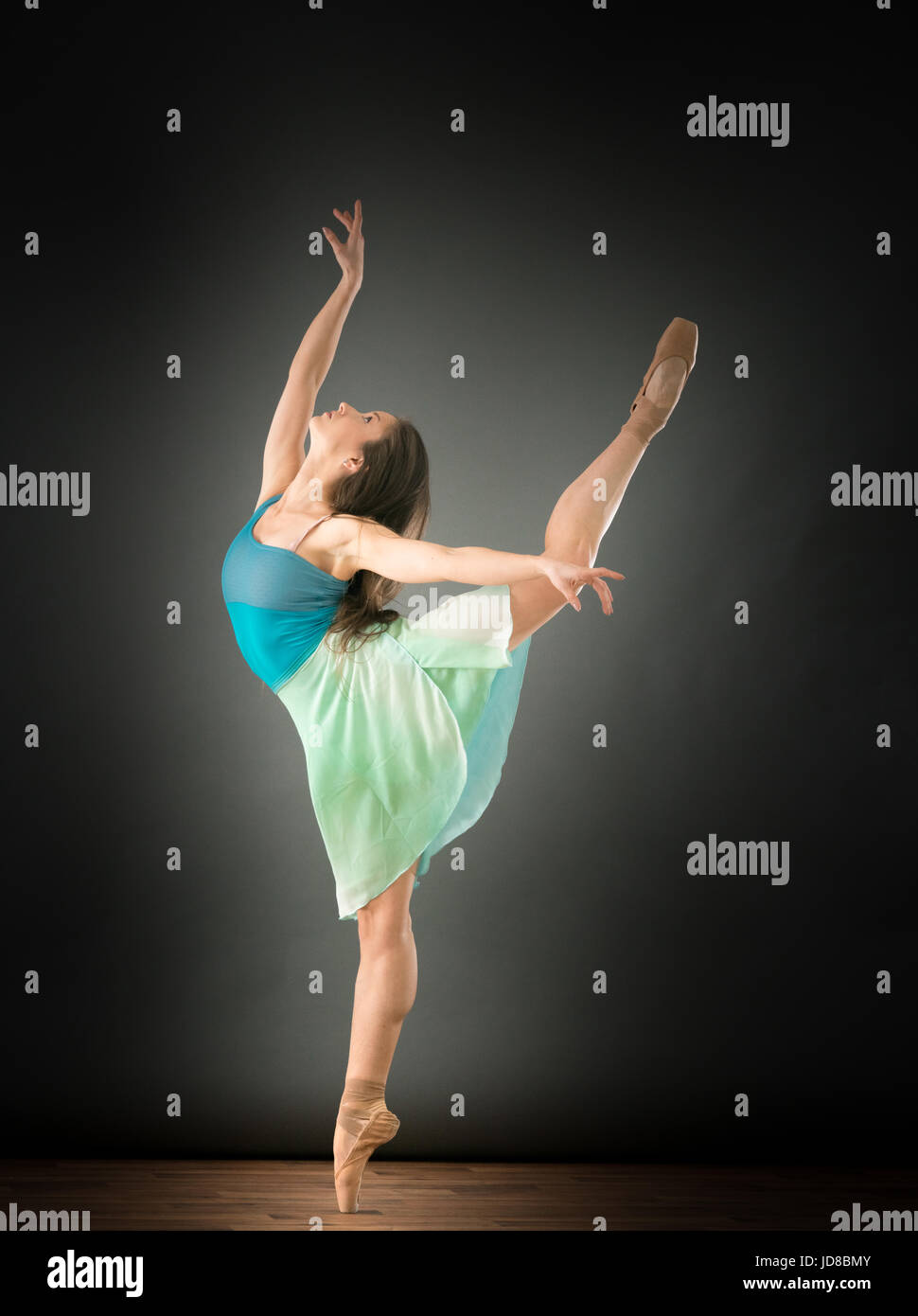 Female ballet dancer on one leg with arms outstretched, studio shot ...