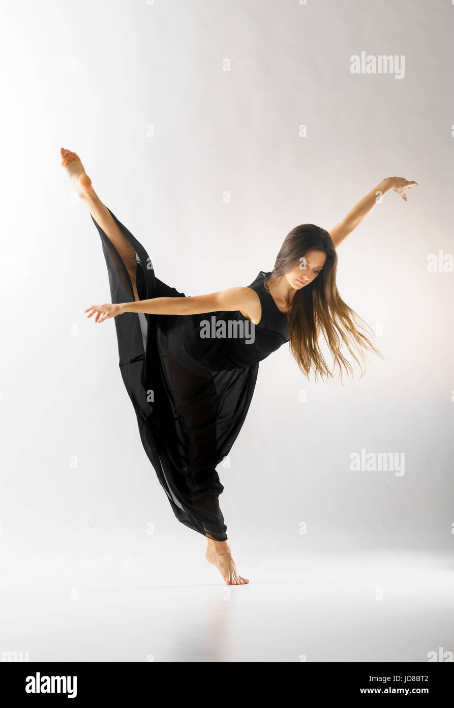 Female ballet dancer on one leg with arms stretched out, studio shot ...
