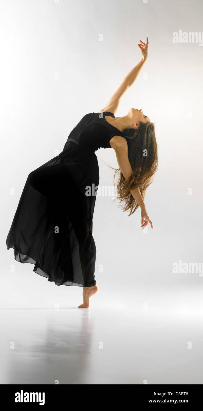 Female ballet dancer on one leg with arms stretched out, studio shot ...