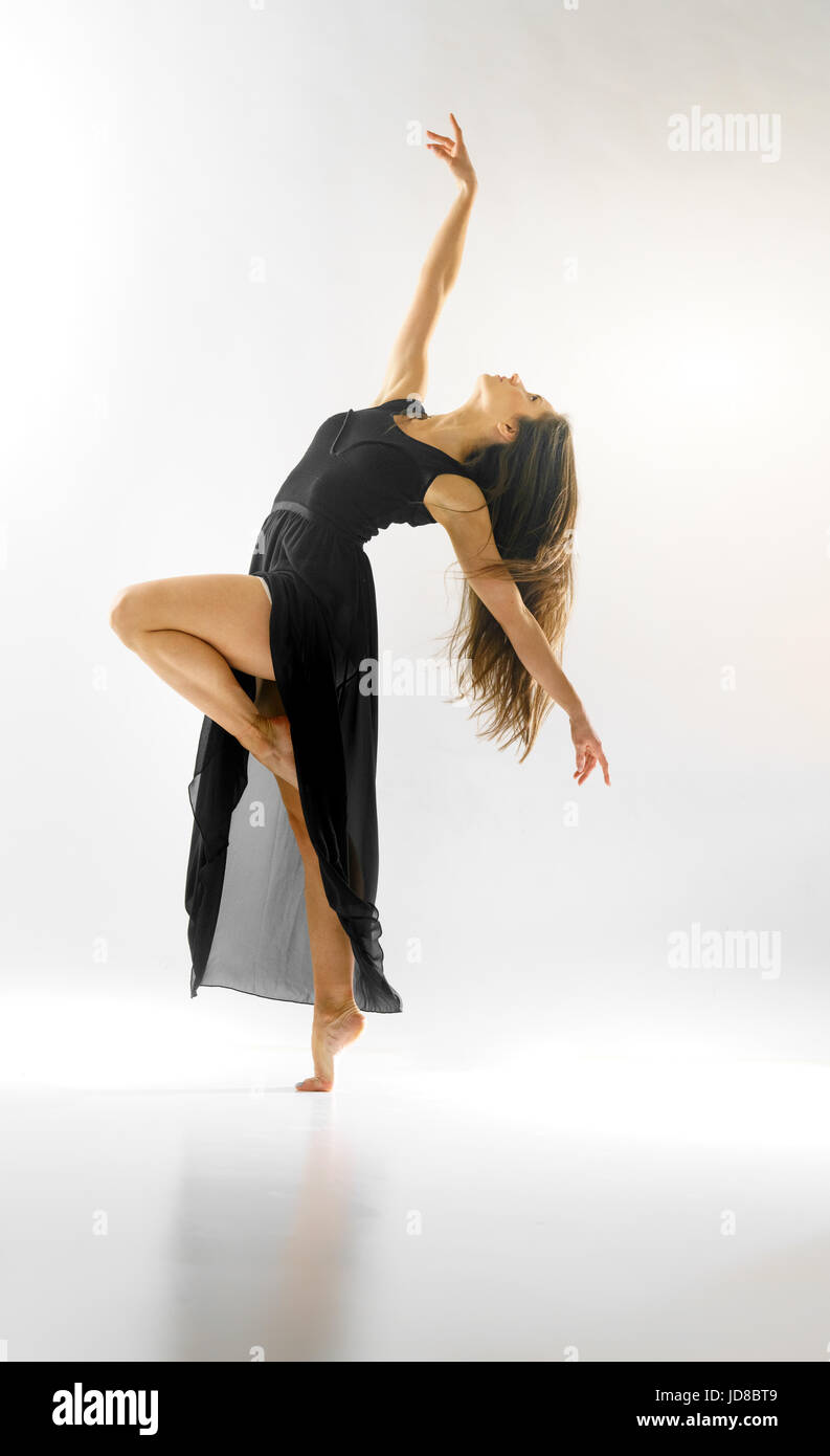 Female ballet dancer on one leg with arms stretched out, studio shot ...