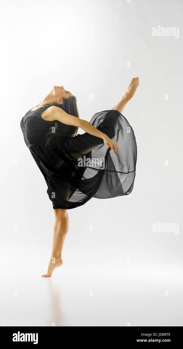 Female ballet dancer on one leg with arms stretched out, studio shot ...