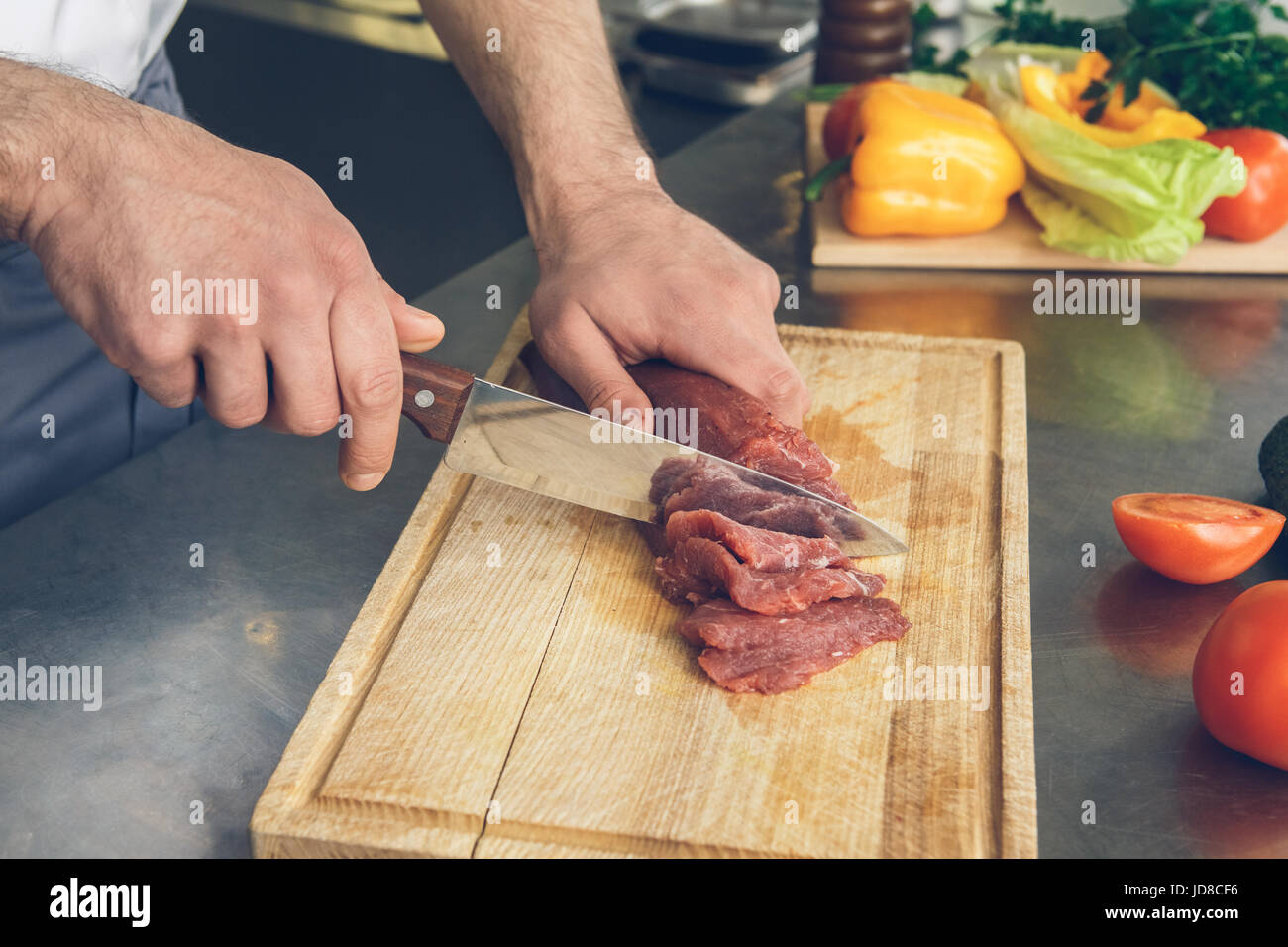 Male japanese restaurant chef cooking in the kitchen cutting ...