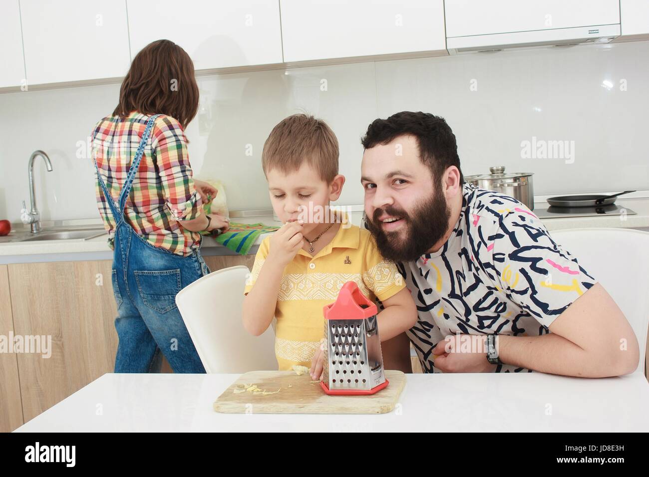 family of three cooking together, happy family in the kitchen, real ...