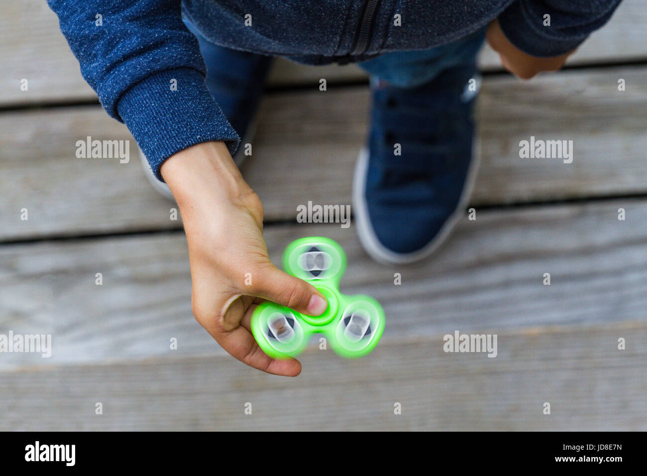 Boy playing with popular fidget spinner toy. Top view Stock Photo - Alamy