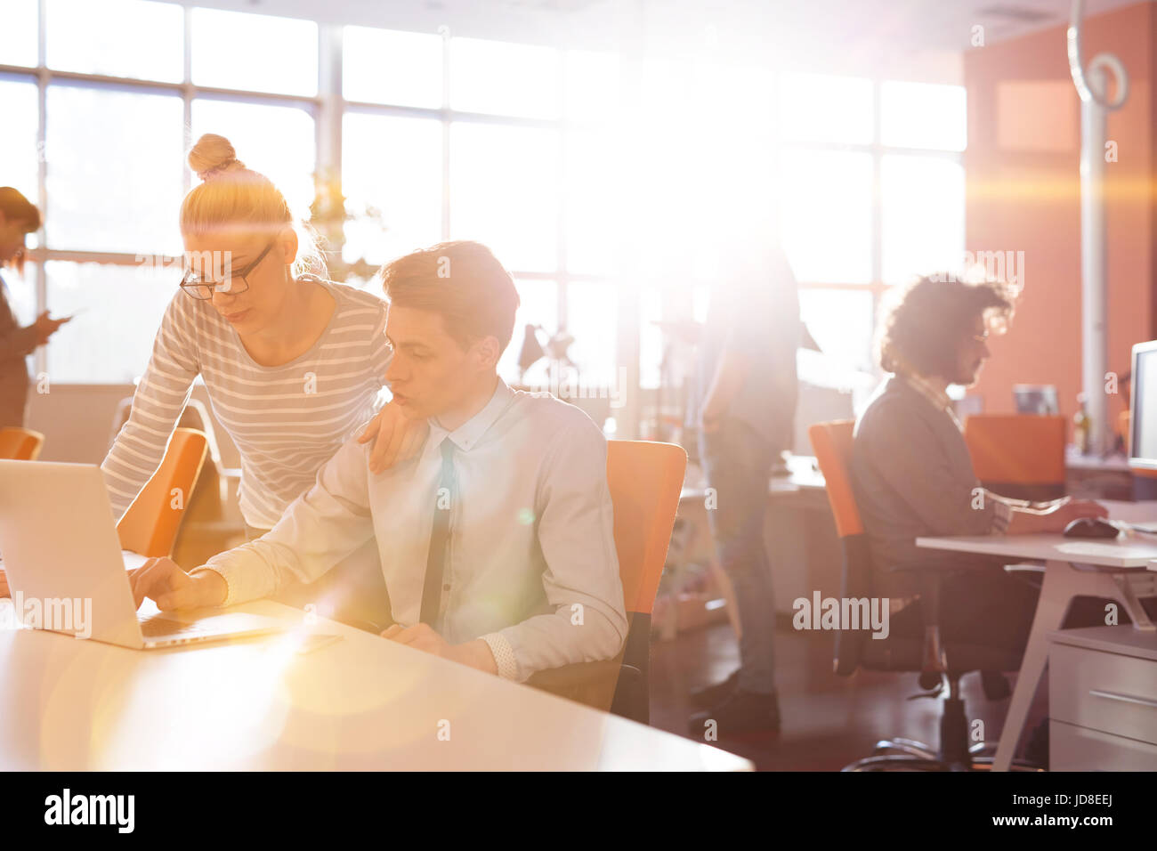 Young businesswoman helping his colleague to fix the problem at the ...