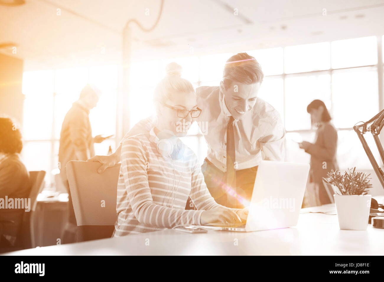 Young businessman helping his colleague to fix the problem at the work ...