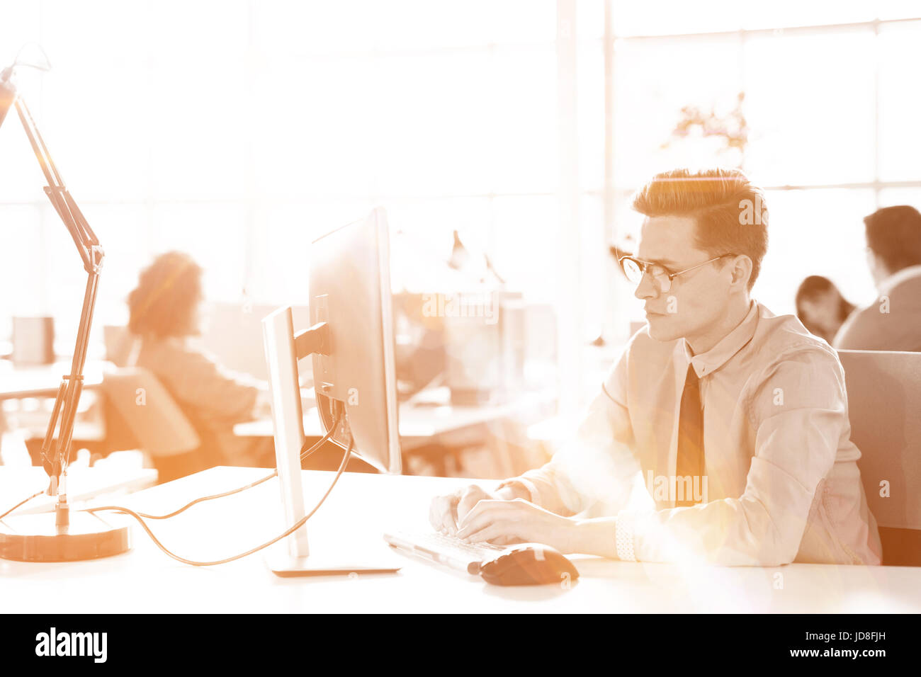 Young businessman programer in big bright office at work using computer ...