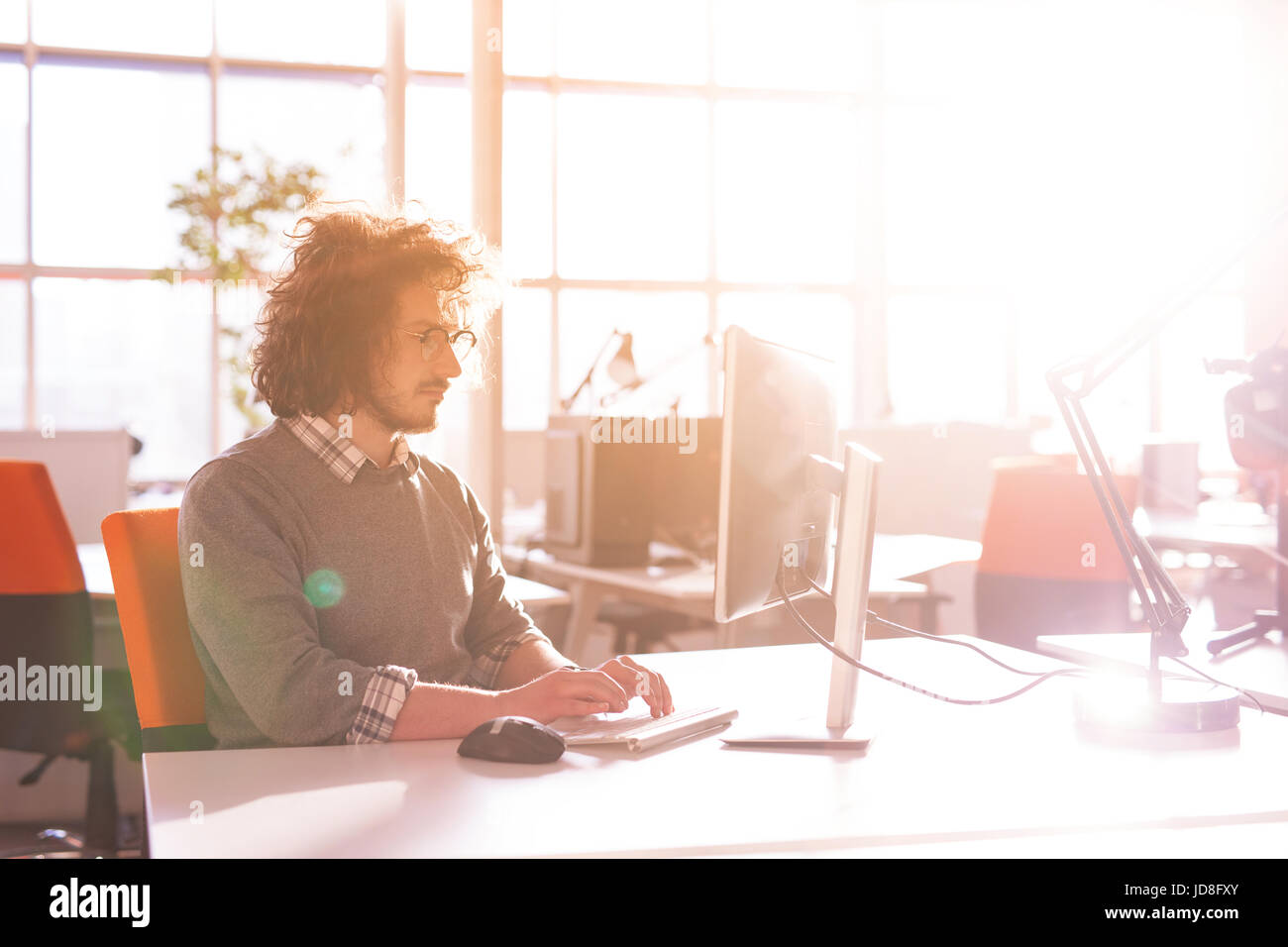 Young businessman programer in big bright office at work using computer ...