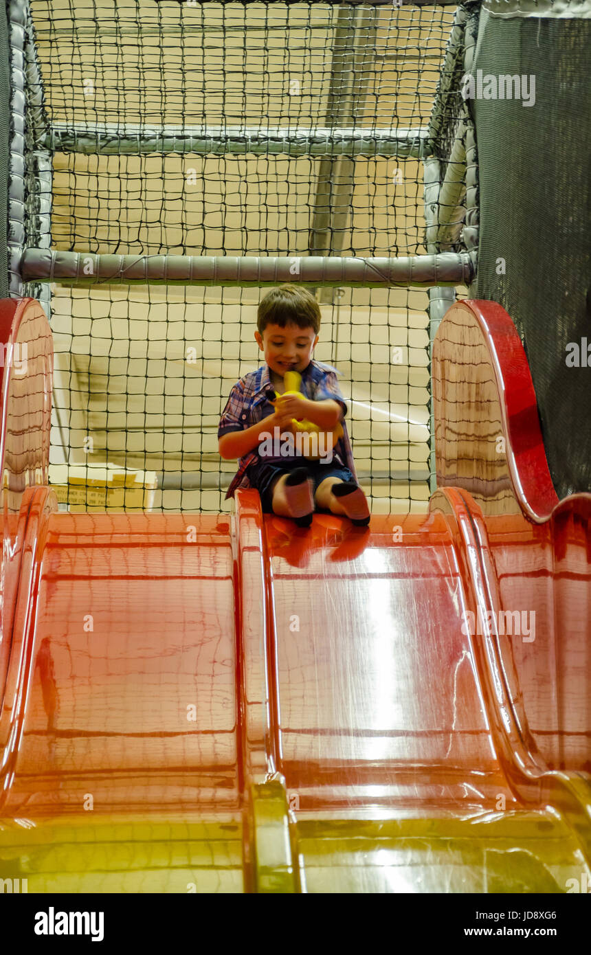 A young boy plays on a slide in a soft play place Stock Photo - Alamy