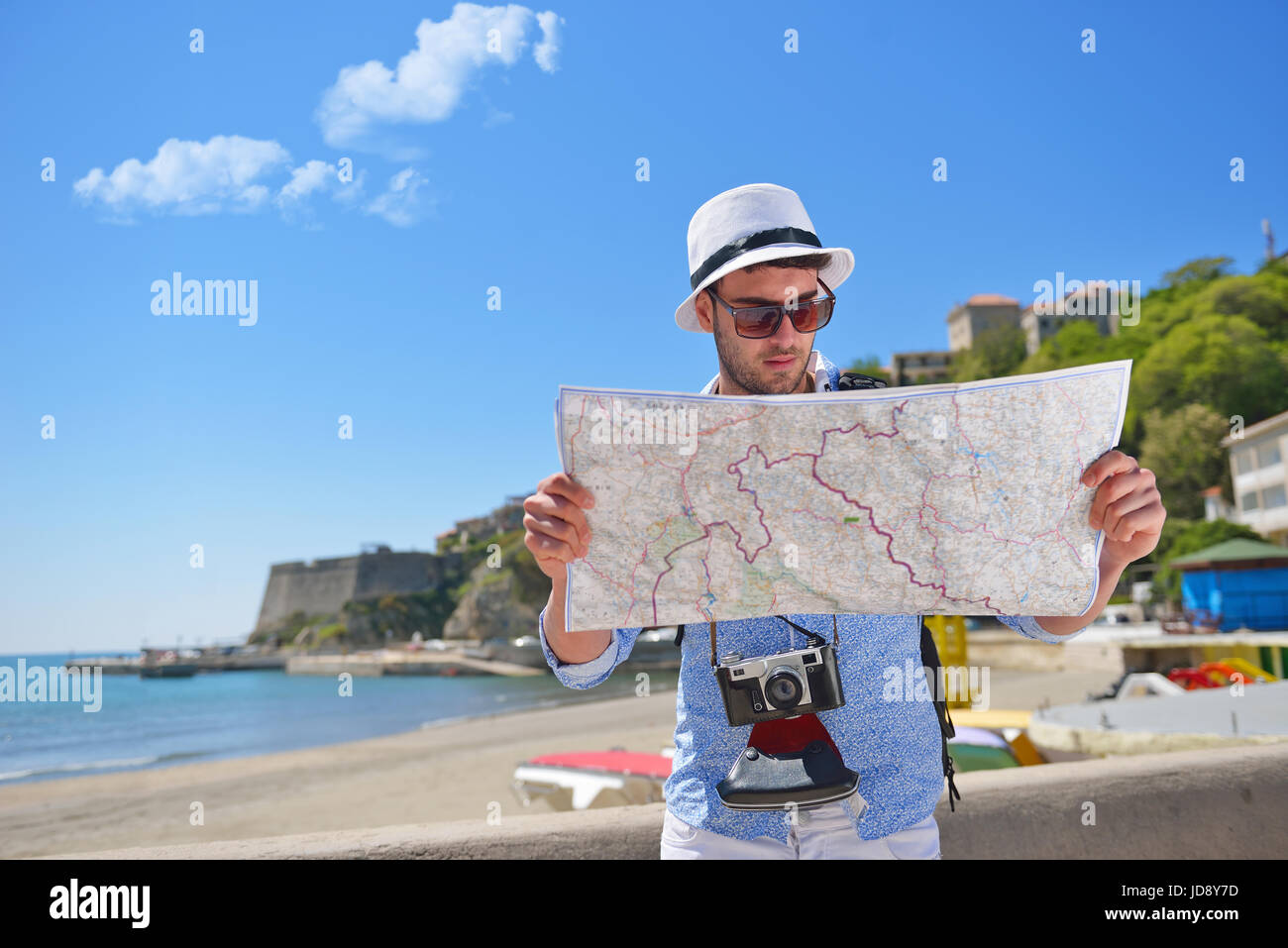 Portrait of a smiling tourist with map and bag Stock Photo - Alamy