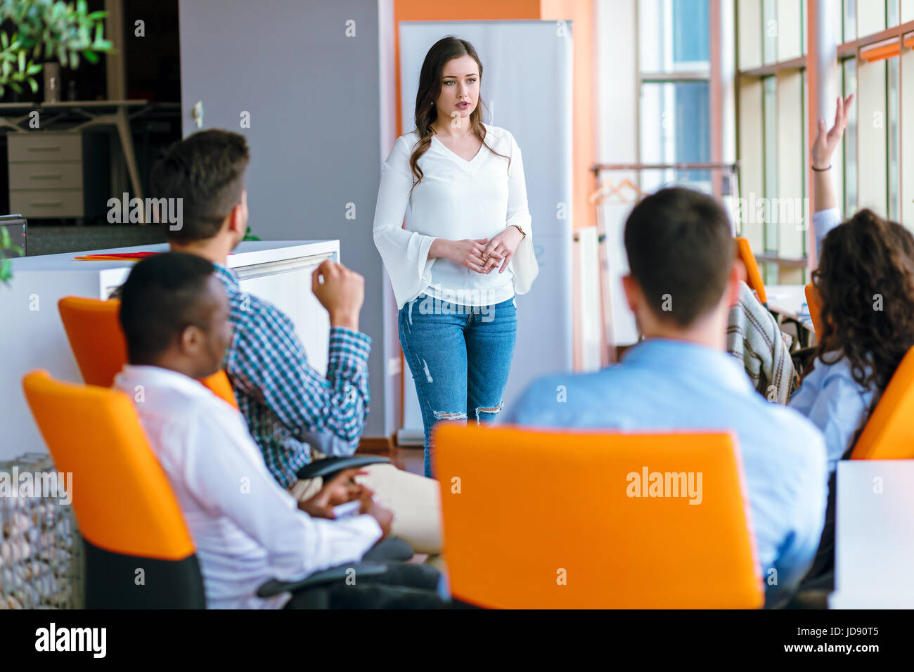 Pretty young business woman giving a presentation in conference or ...