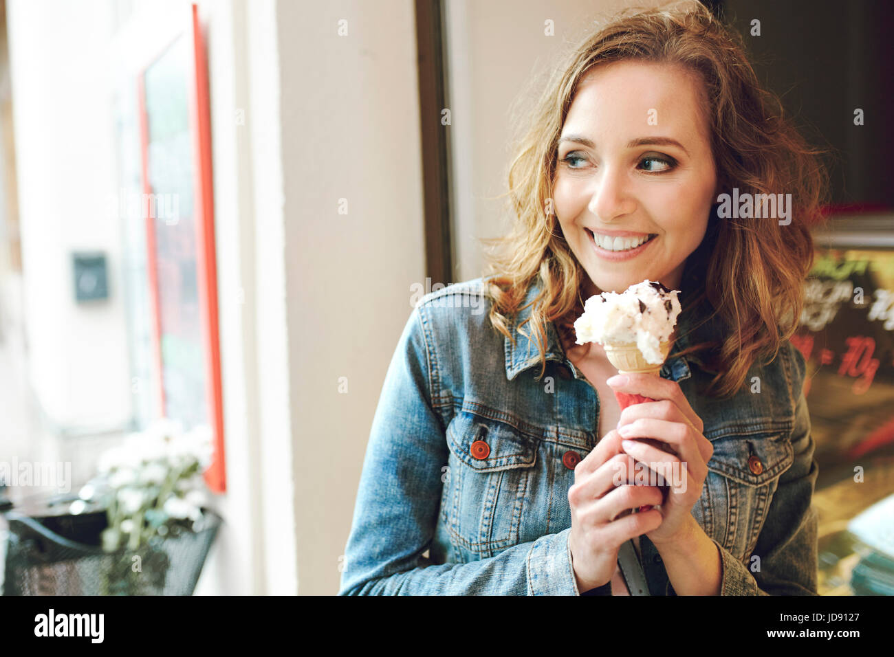 Smiling woman eating ice cream Stock Photo - Alamy