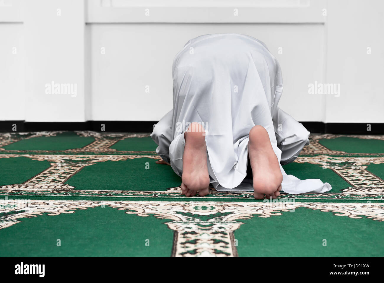 Portrait of asian muslim man with traditional dress praying inside the ...
