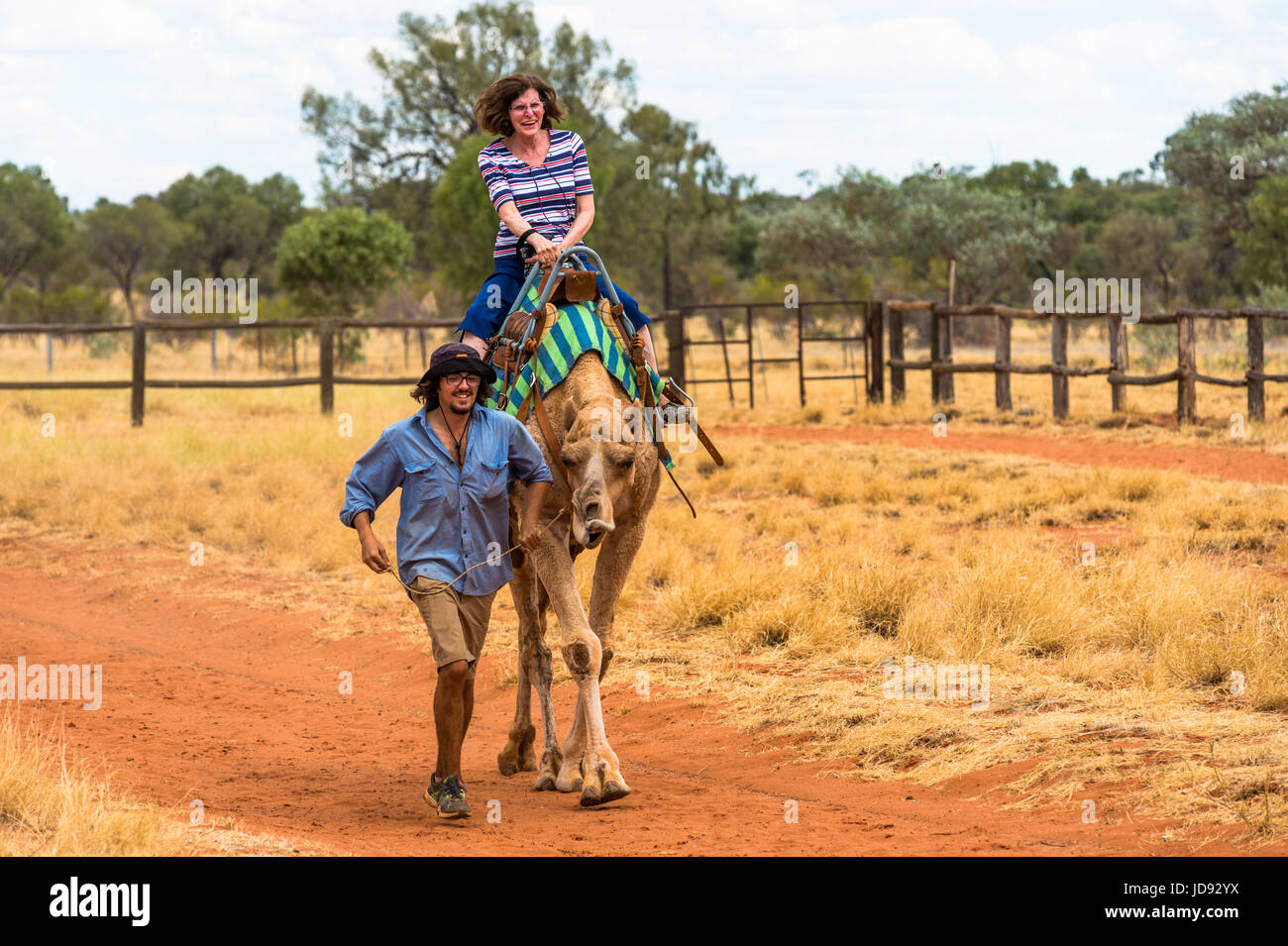 Tourists ride the camels at Outback camel farm. Northern Territory ...