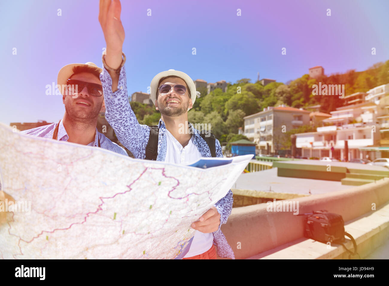 Portrait of a smiling tourist with map and bag Stock Photo - Alamy
