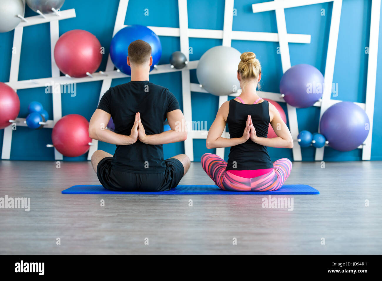 Nice couple doing yoga in a studio. Young people in yoga class in ...