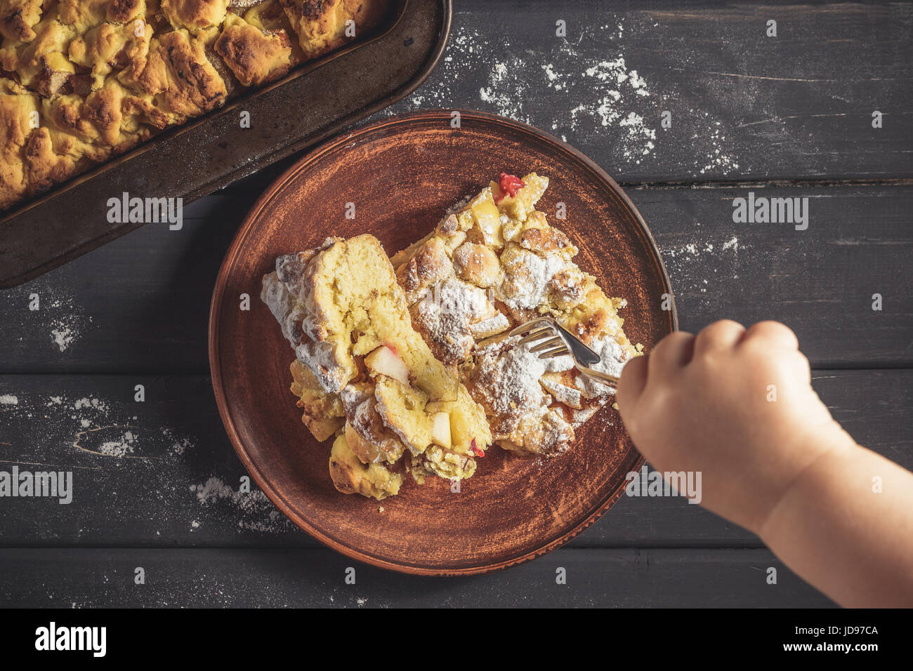 Kid's hand is trying to pick up a piece of pie with a small fork Stock ...