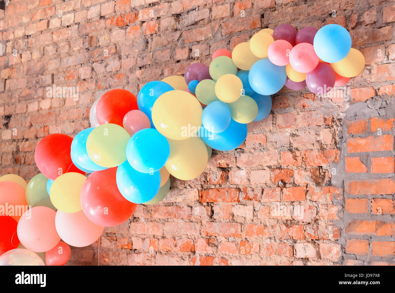 Set of multi-colored balls attached to a brick wall Stock Photo - Alamy