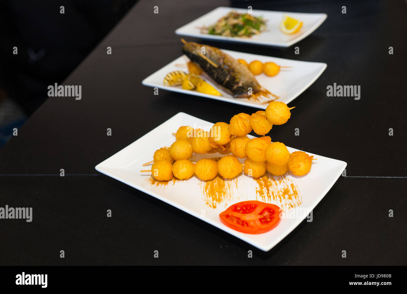 Delicious fried cheese and fish on white plates on the table Stock ...