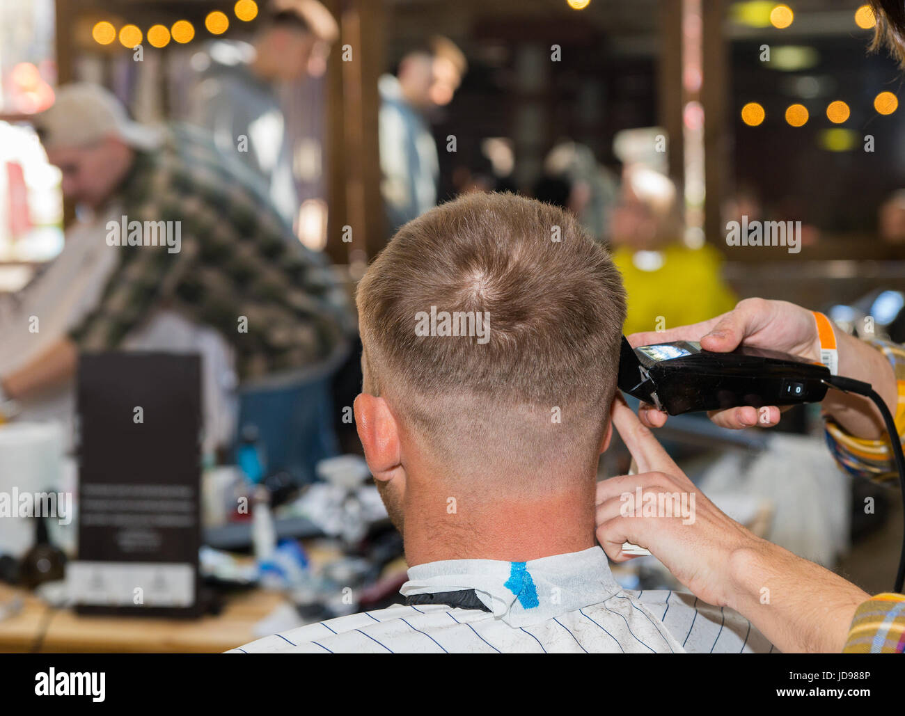 Close up of young man having a haircut and side of head shaved by ...